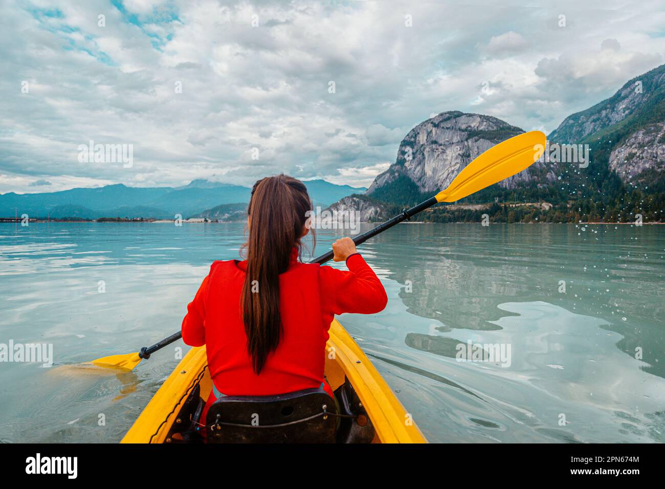 Woman kayaking in Squamish paddling in kayak in Howe Sound a fjord ...
