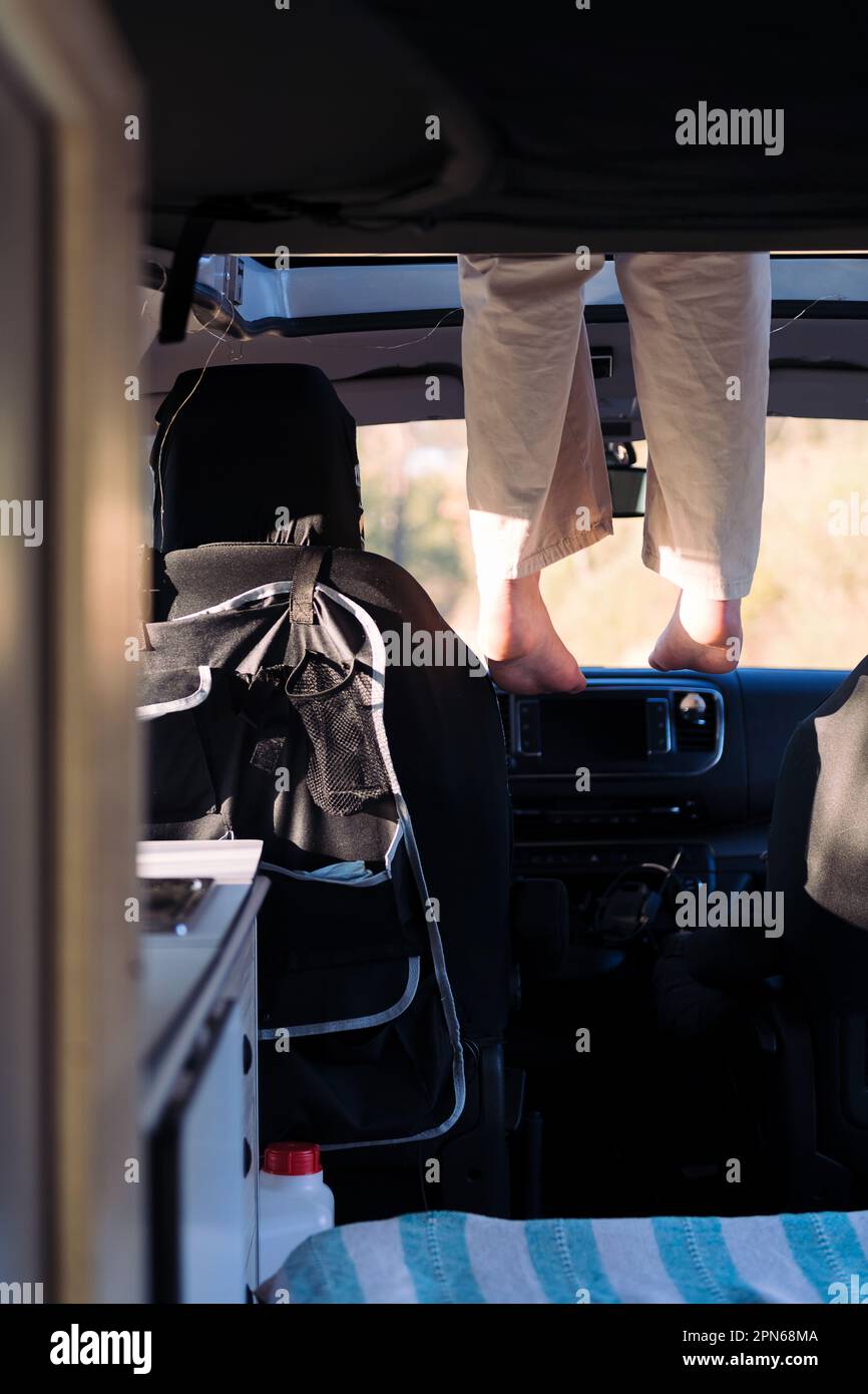 feet dangling off the elevated bed of a camper van Stock Photo - Alamy