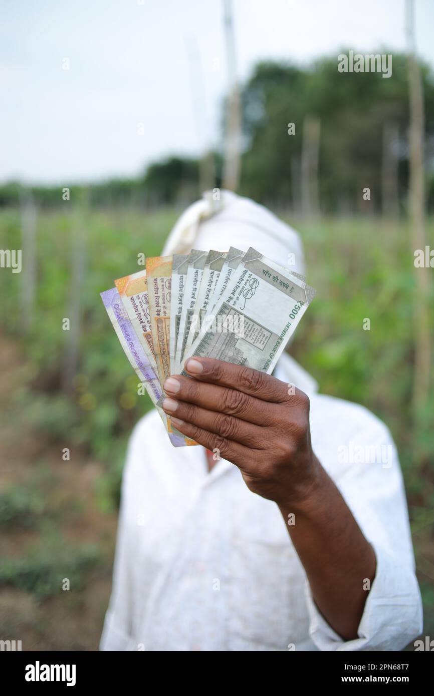 ndian farmer holding cash in hands, Indian rupees, happy farmer Stock ...