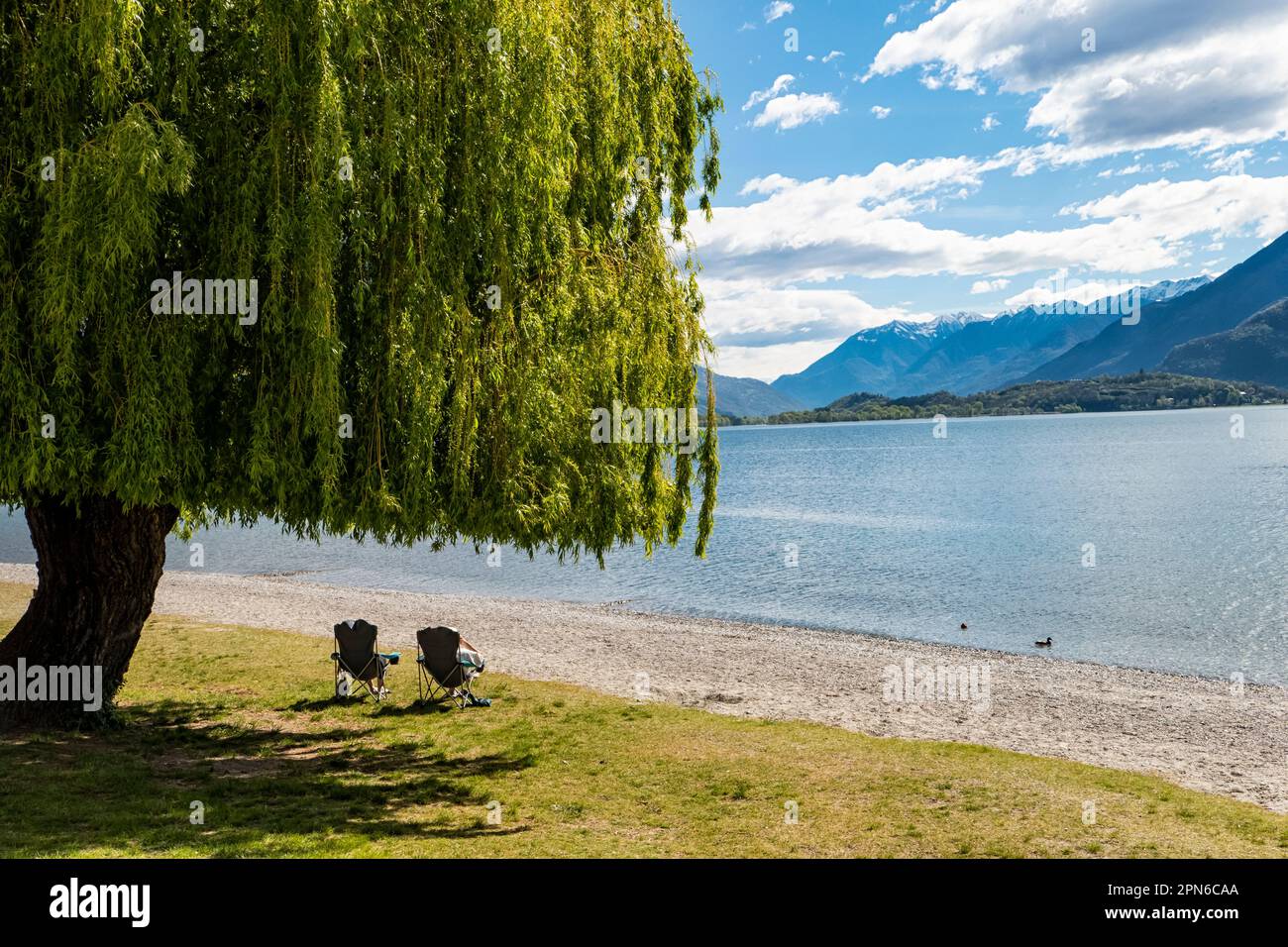 Relaxation scene on a beach of Lake Como Stock Photo - Alamy