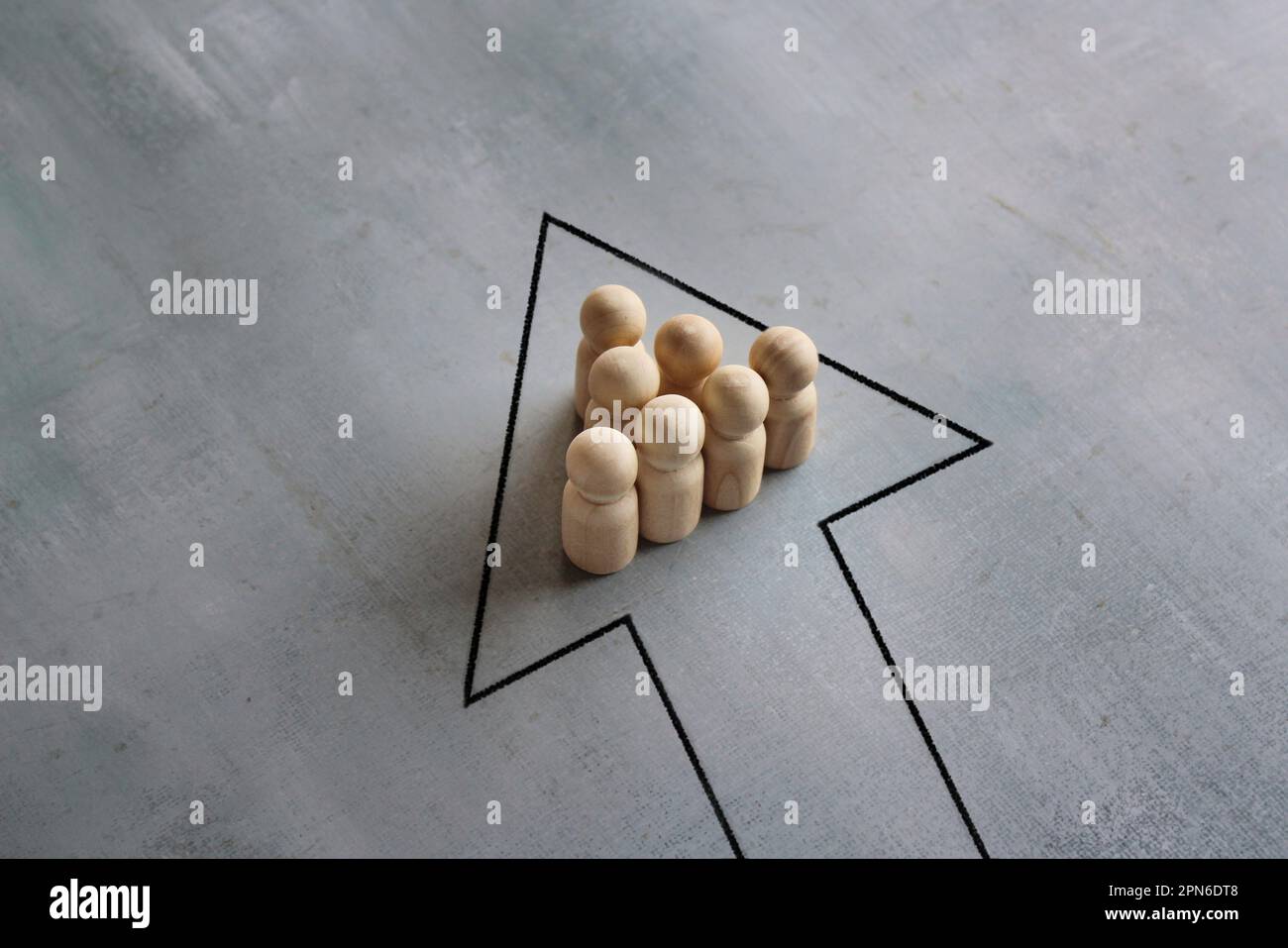 Group of wooden dolls and upward arrow. Leader lead team going forward, teamwork and progress ...