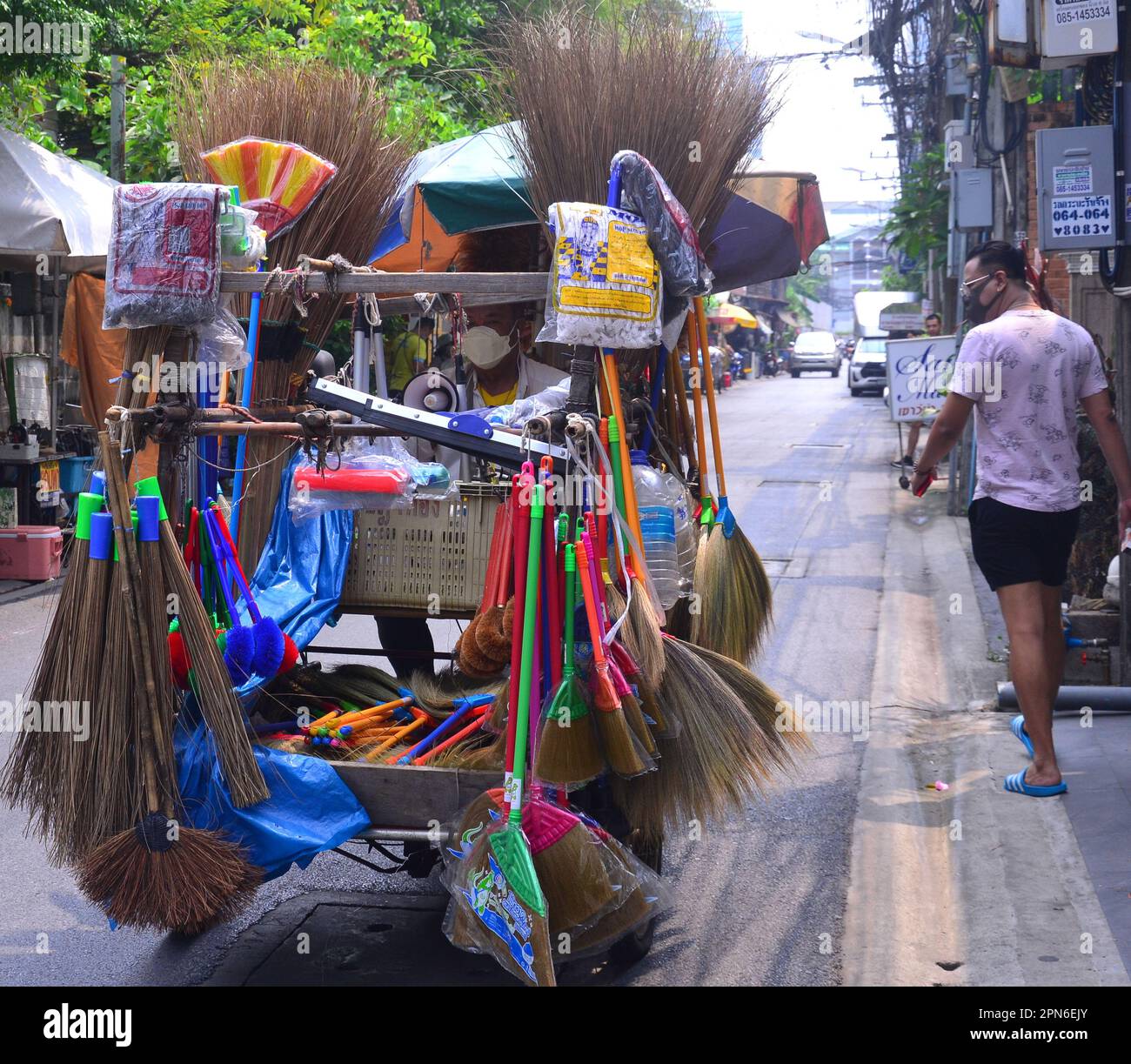 A man cycles a trolley laden with different sorts of brushes to sell ...