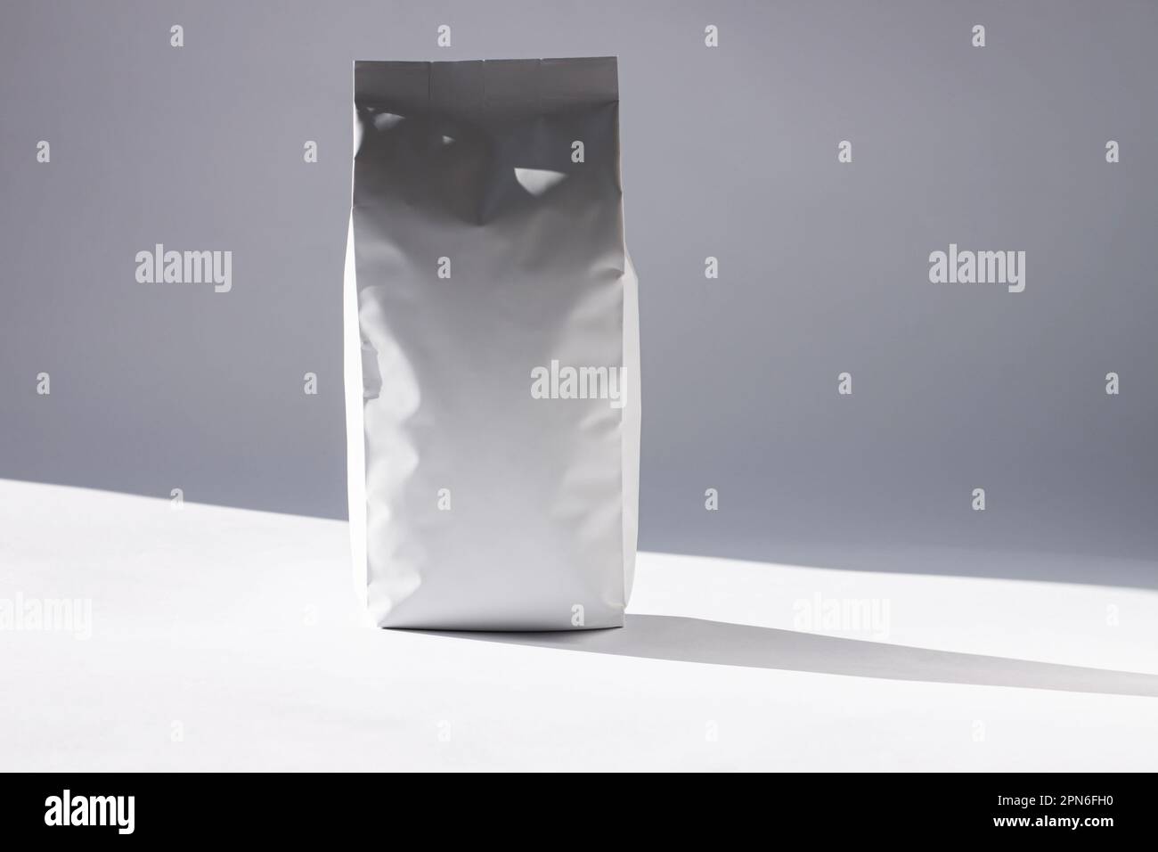 Blank white foil bag on monochrome background in minimal style with ...