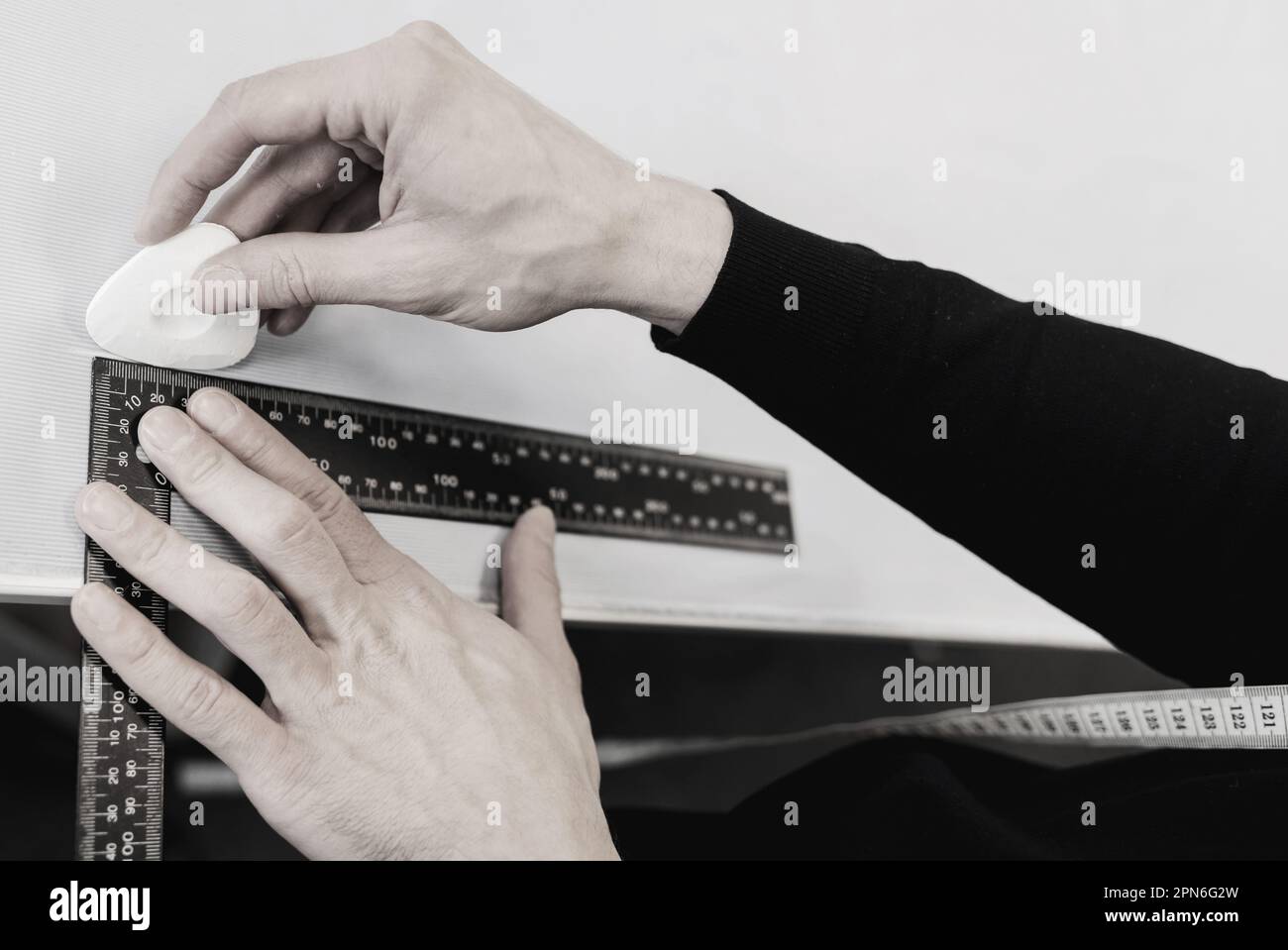 tailor with a ruler and chalk marks clothes. hand of professional ...