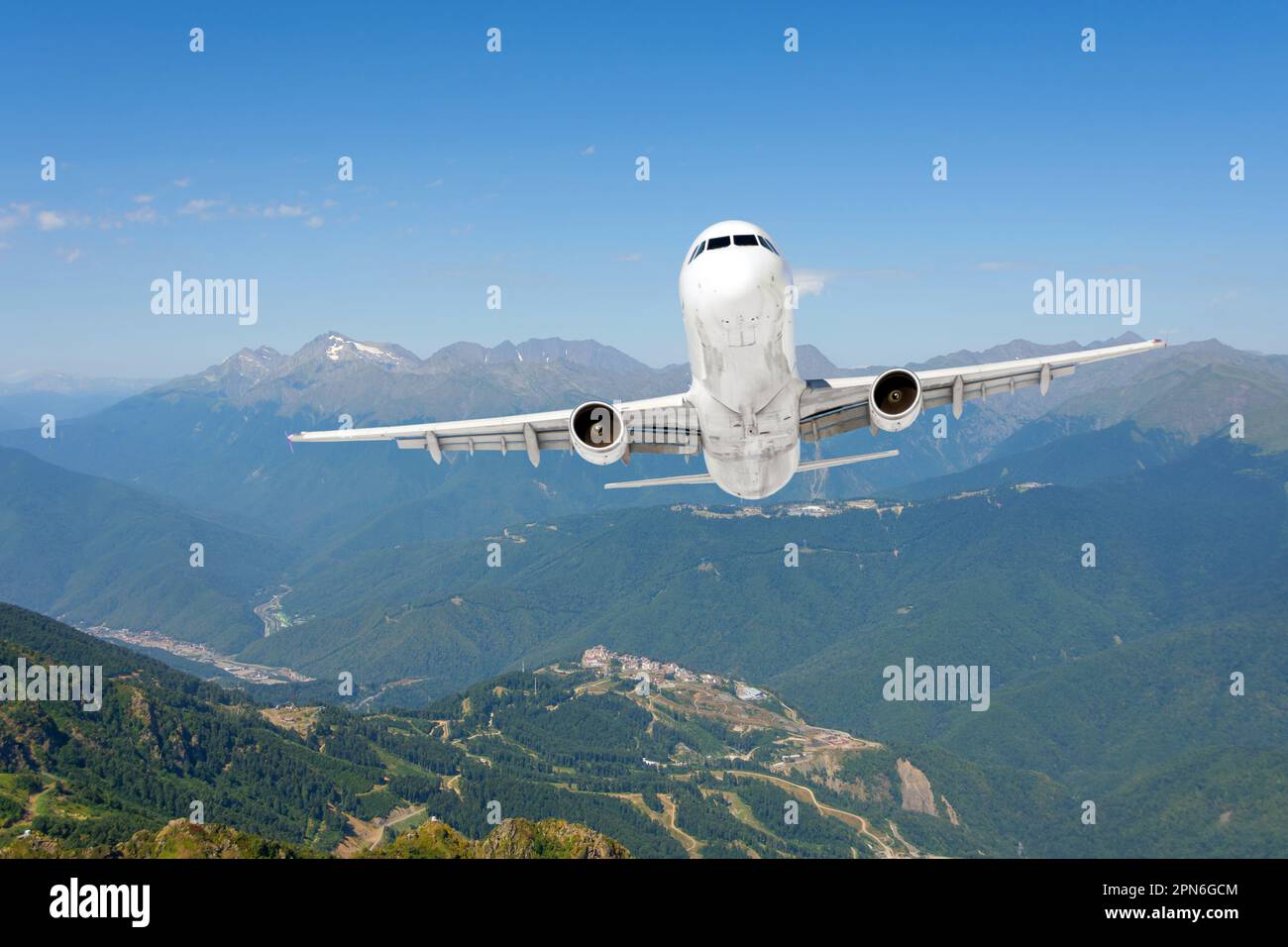 Airplane is flying over town mountains forest. Amazing landscape with ...