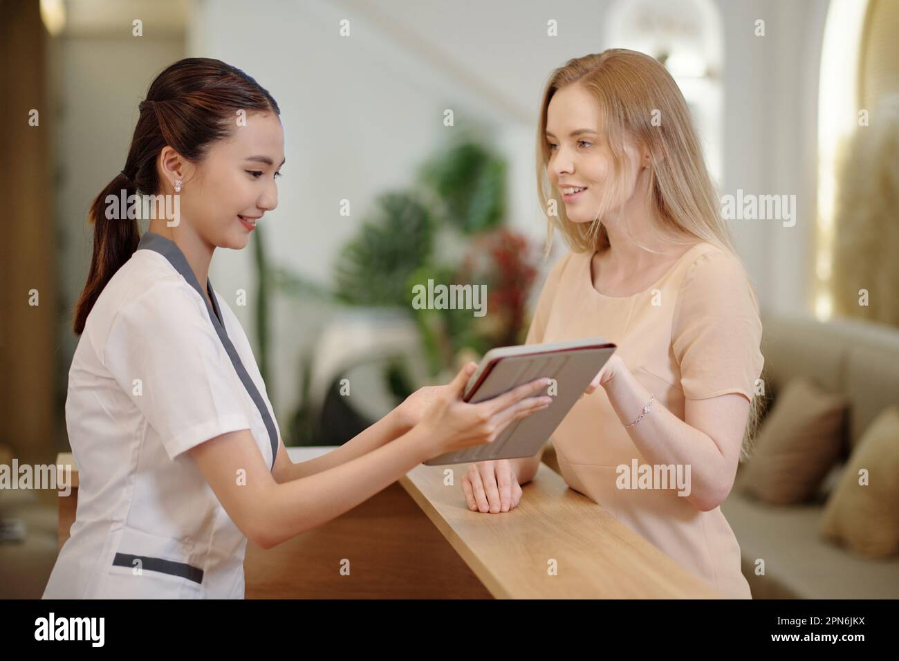 Spa salon receptionist talking to client offering new procedure Stock ...