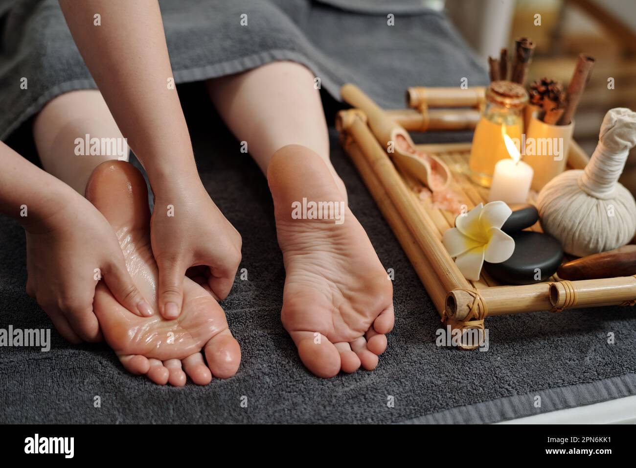 Therapist stimulating points on feet of client Stock Photo - Alamy