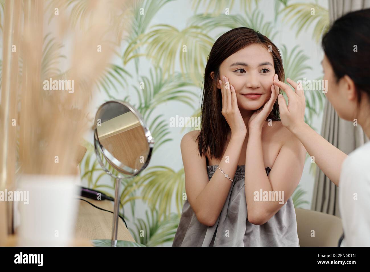 Excite young woman touching her soft skin after getting spa procedure ...