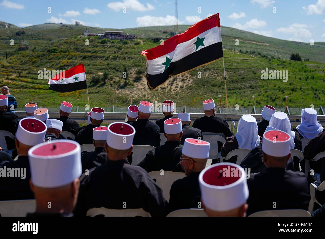 Druze men sit with Syrian flags during a rally marking Syria's ...