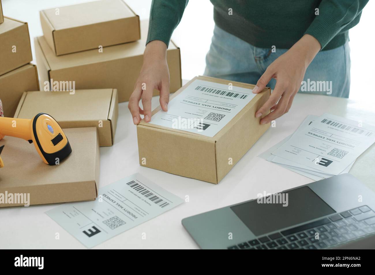 Female online store, business owner putting label tag on parcel Stock ...