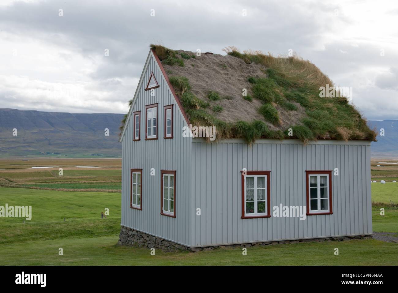 Traditional white farmhouse with red windows Stock Photo - Alamy