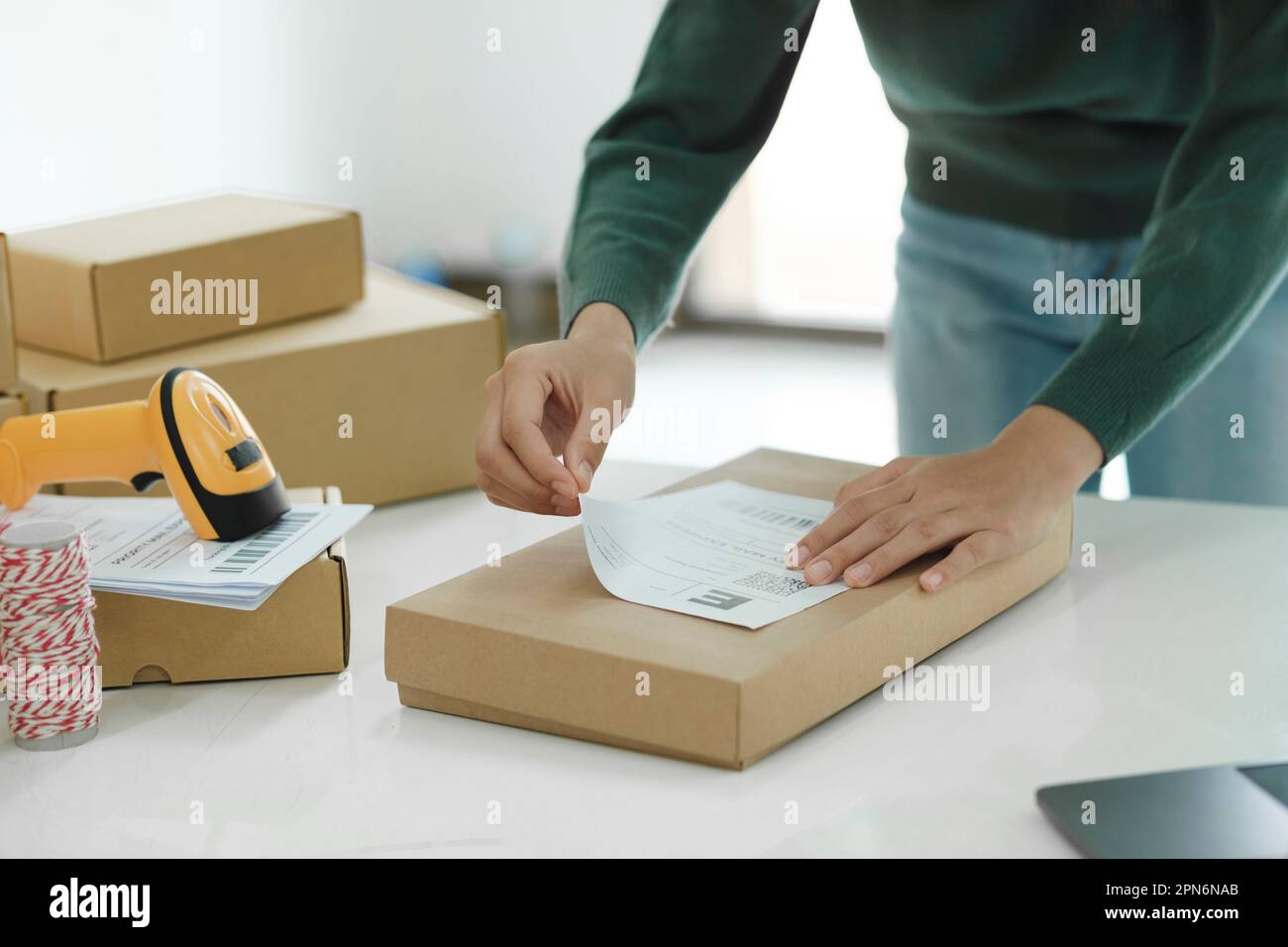 Young business owner putting shipping label on parcel Stock Photo - Alamy