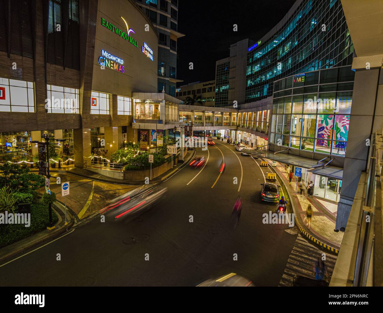 Night street scene from Eastwood neighborhood in Manila with long time ...