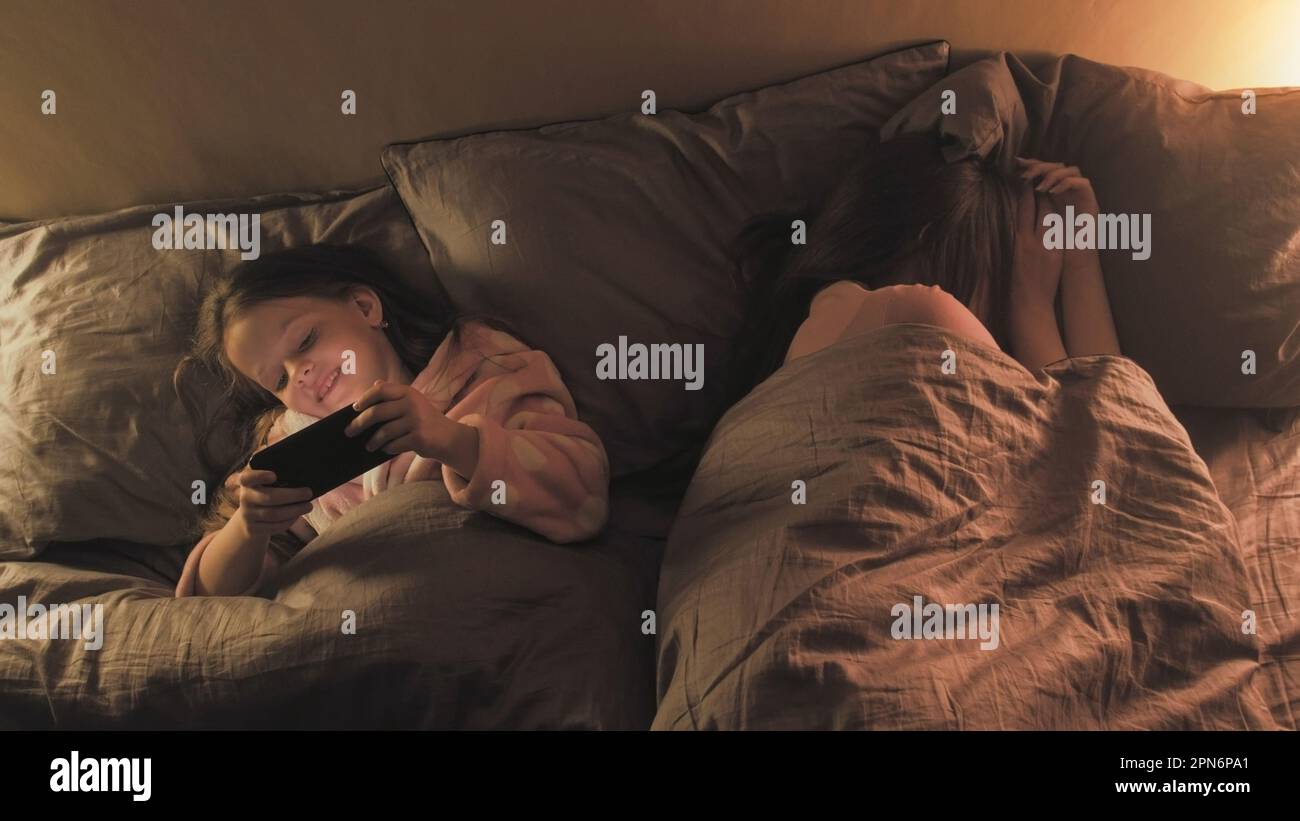 Bedtime movie child gadget night daughter phone Stock Photo - Alamy
