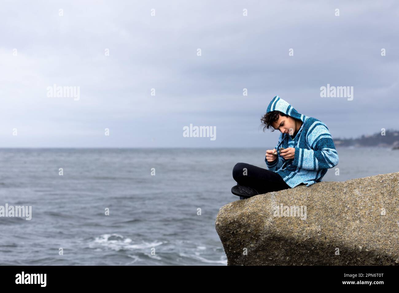 Boy sitting on rocks beach hi-res stock photography and images - Alamy