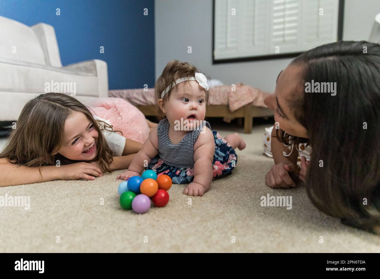 Special needs infant playing with family inside Stock Photo - Alamy