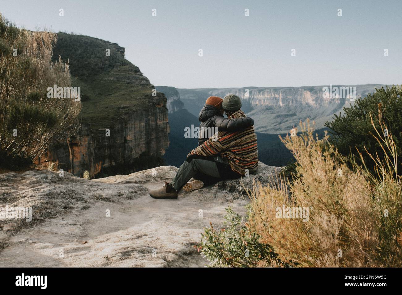 Couple cuddling on a mountain top with a view Stock Photo - Alamy
