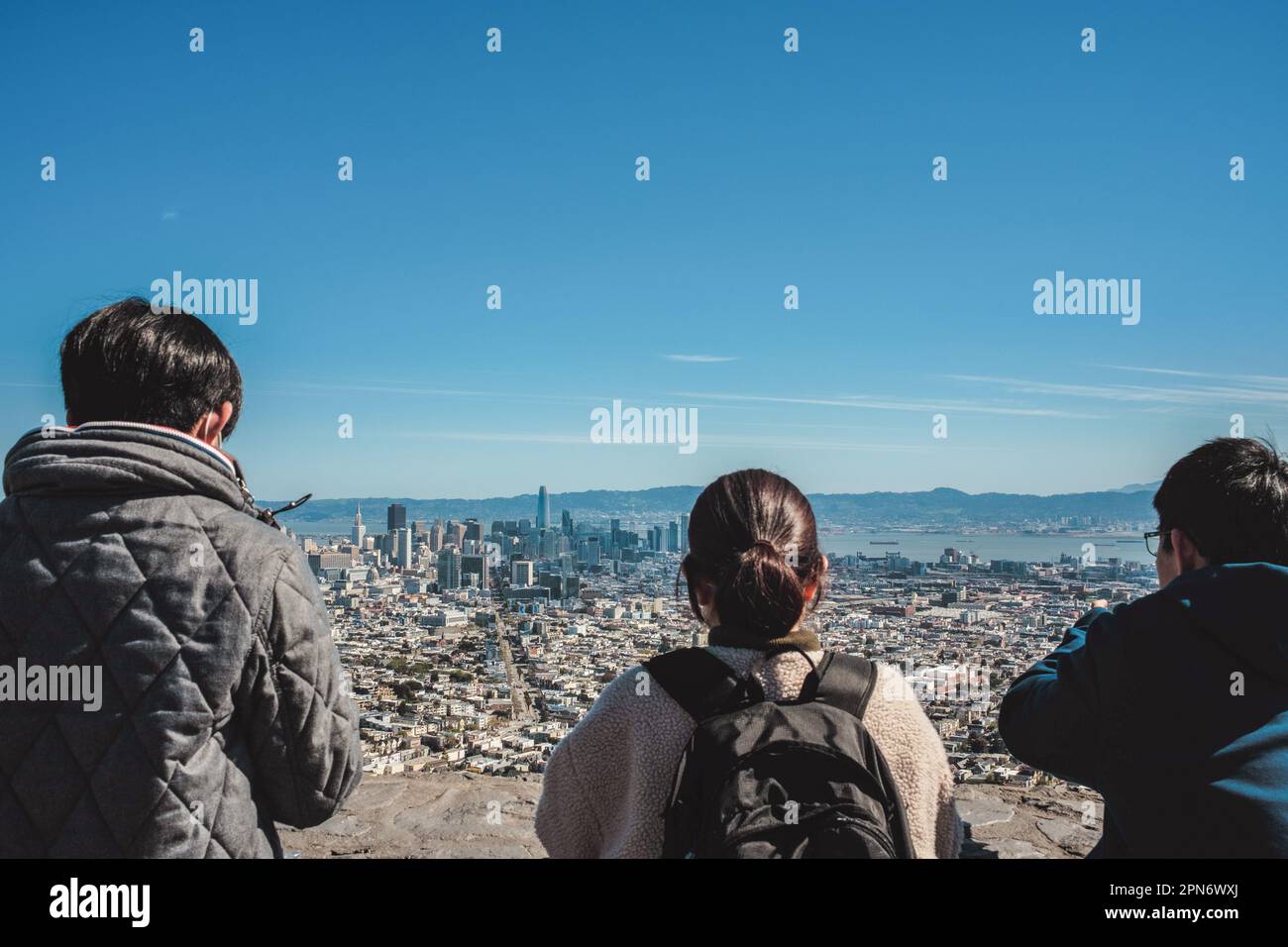 A group of tourists admiring the view from Twin Peaks. San Francisco is ...