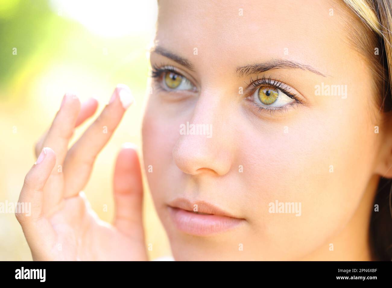 Close up portrait of a beauty woman hand applying moisturizer on face ...