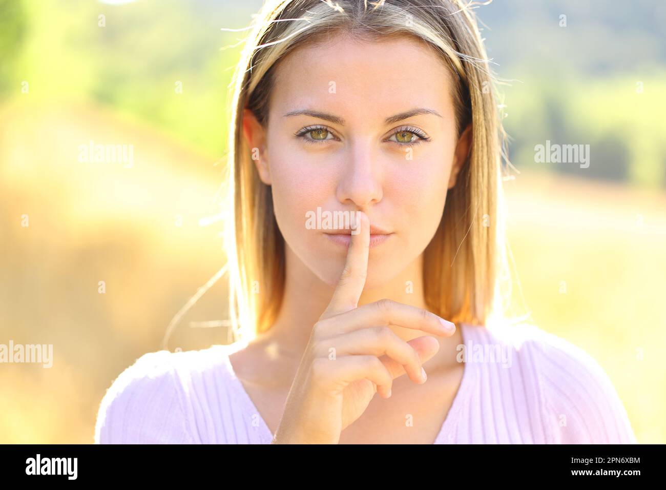 Front view portrait of a beautiful woman asking for silence in nature ...