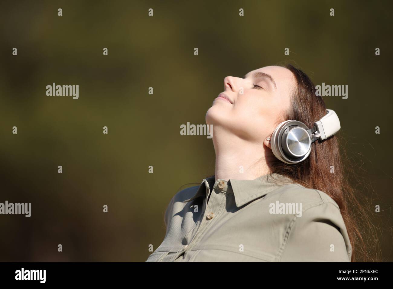 Woman meditating outside listening audio guide with headphone Stock ...