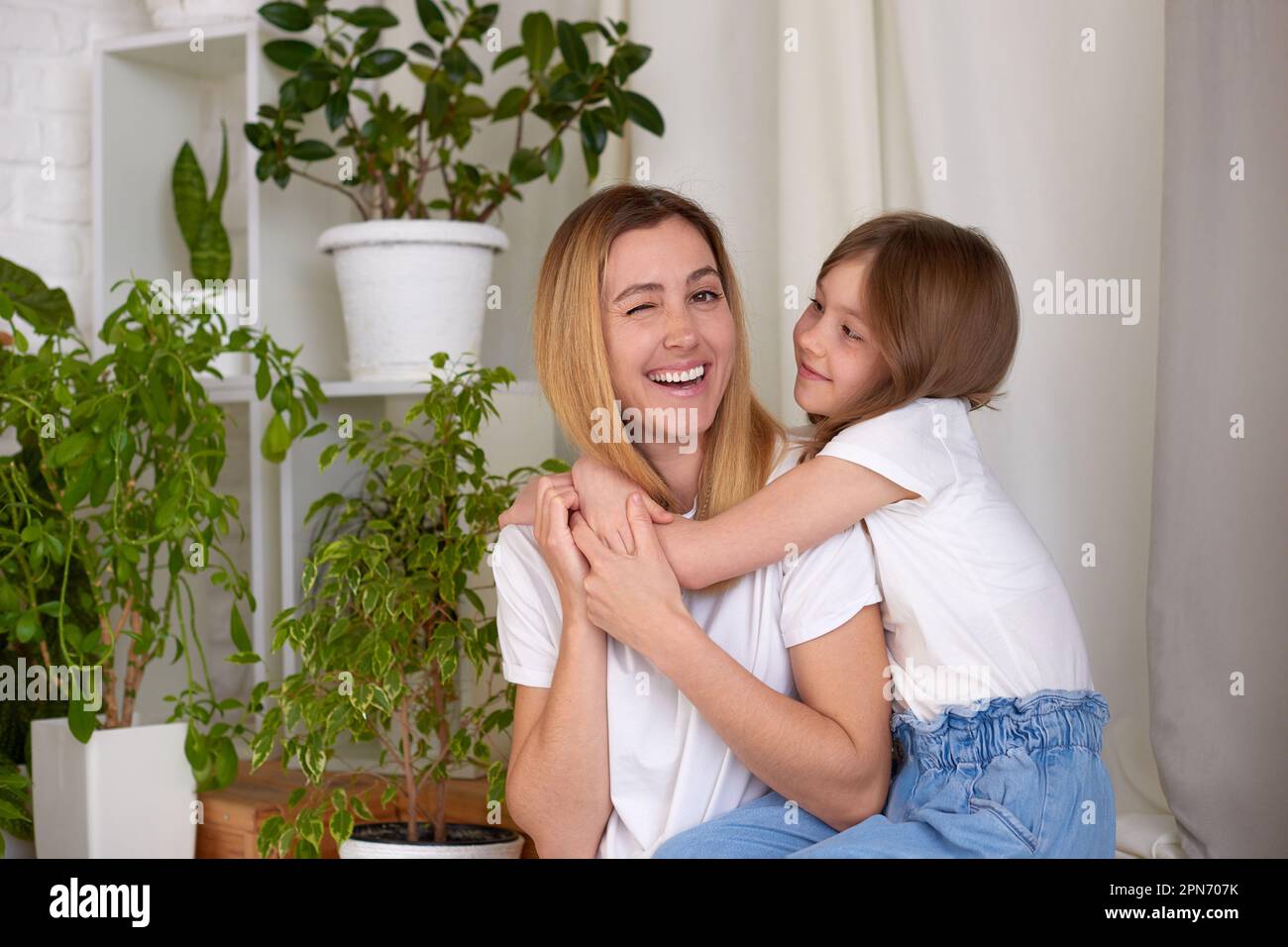 mother and daughter enjoying a tender moment, hugging and holding hands. happy family spending ...