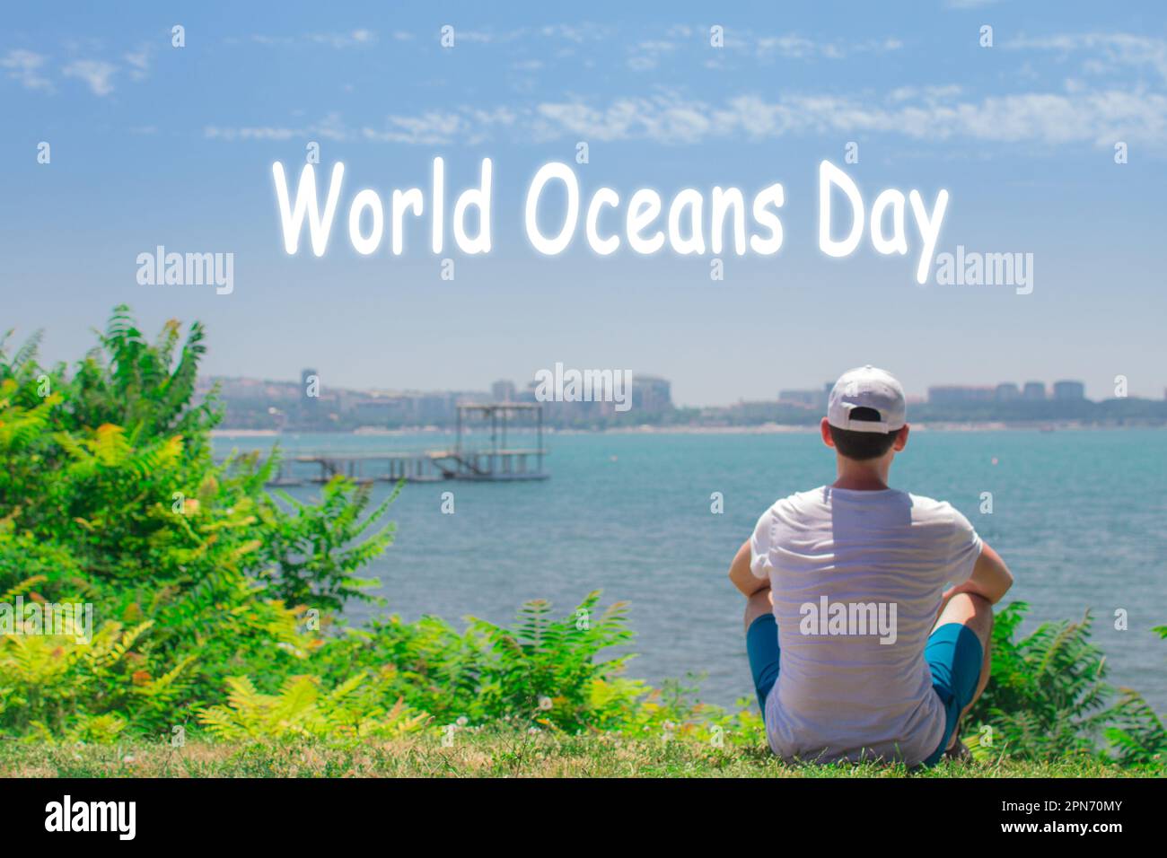 World Ocean Day, man sitting at the sea with his back looking into the ...