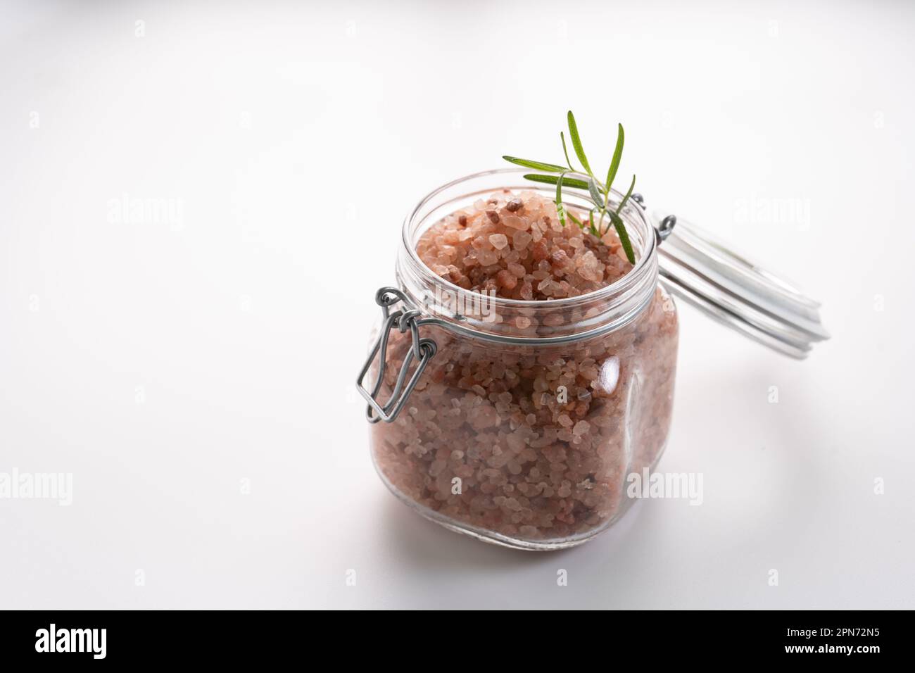 Himalayan pink salt on glass of jar isolated on white background with ...
