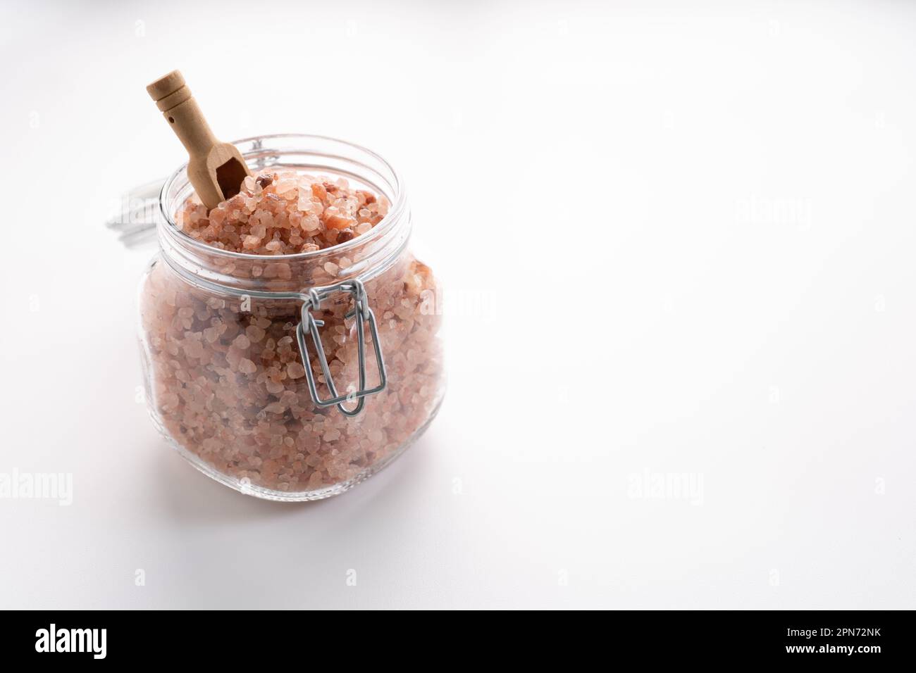 Himalayan pink salt on glass of jar isolated on white background with ...