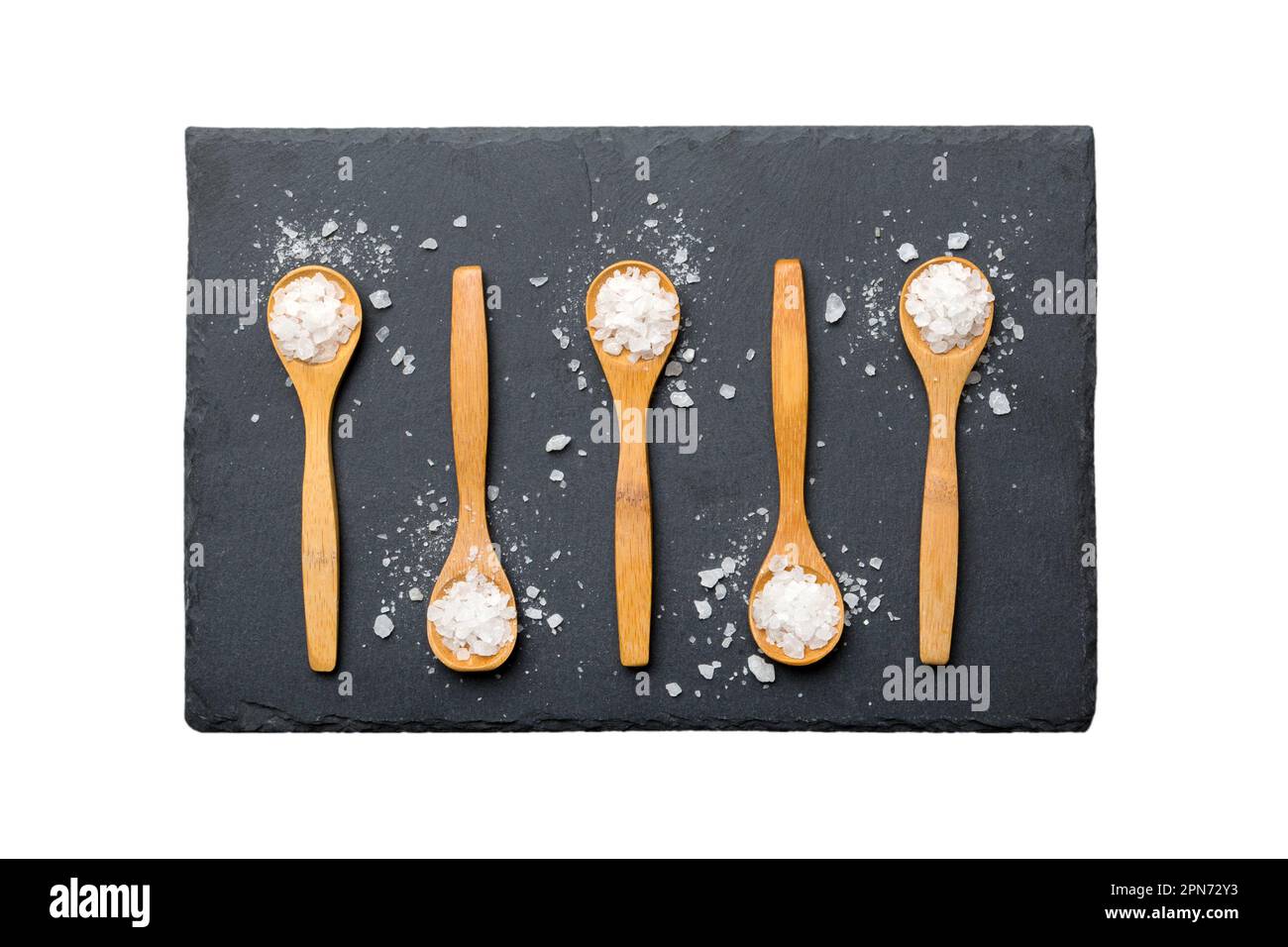 salt on many wooden spoon isolated on white background. Spoons with ...