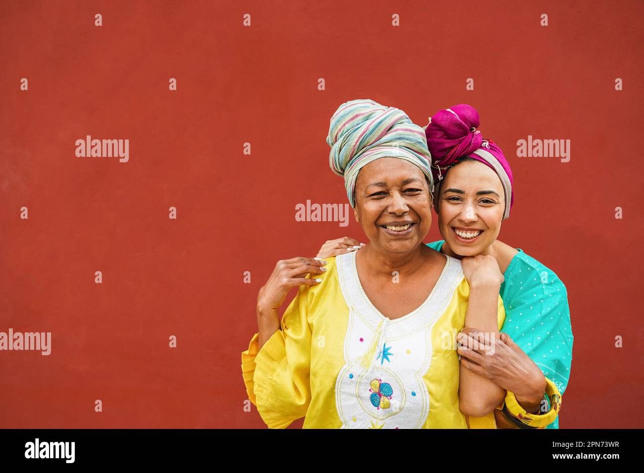Happy african mother and her daughter wearing ethnic afro clothes while ...