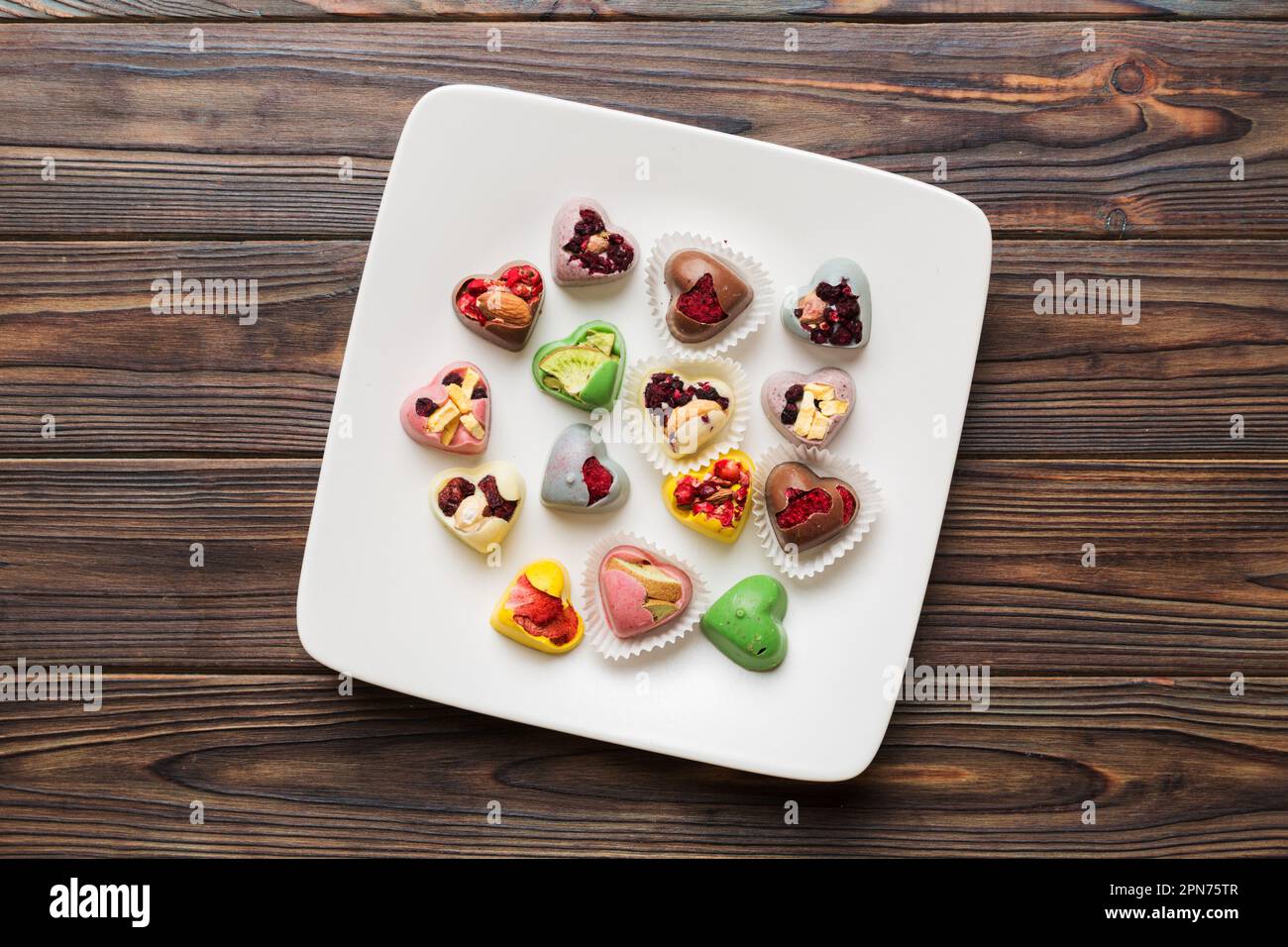 Plate with different chocolate on colored background. Assortment of ...