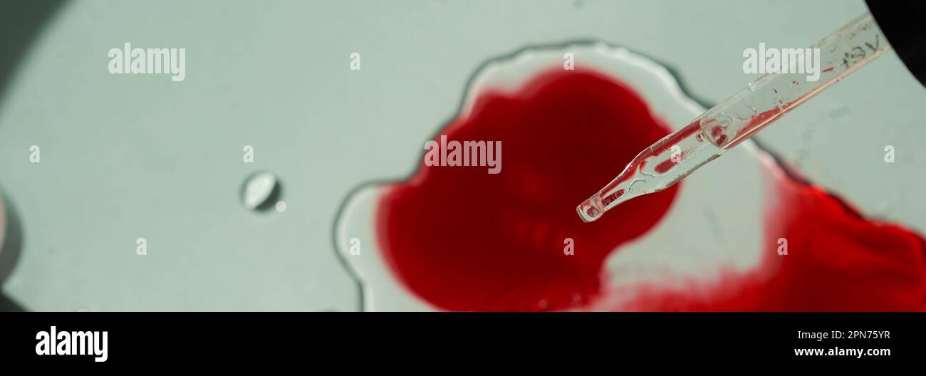Red liquid with a pipette in the form of a spot in the container ...
