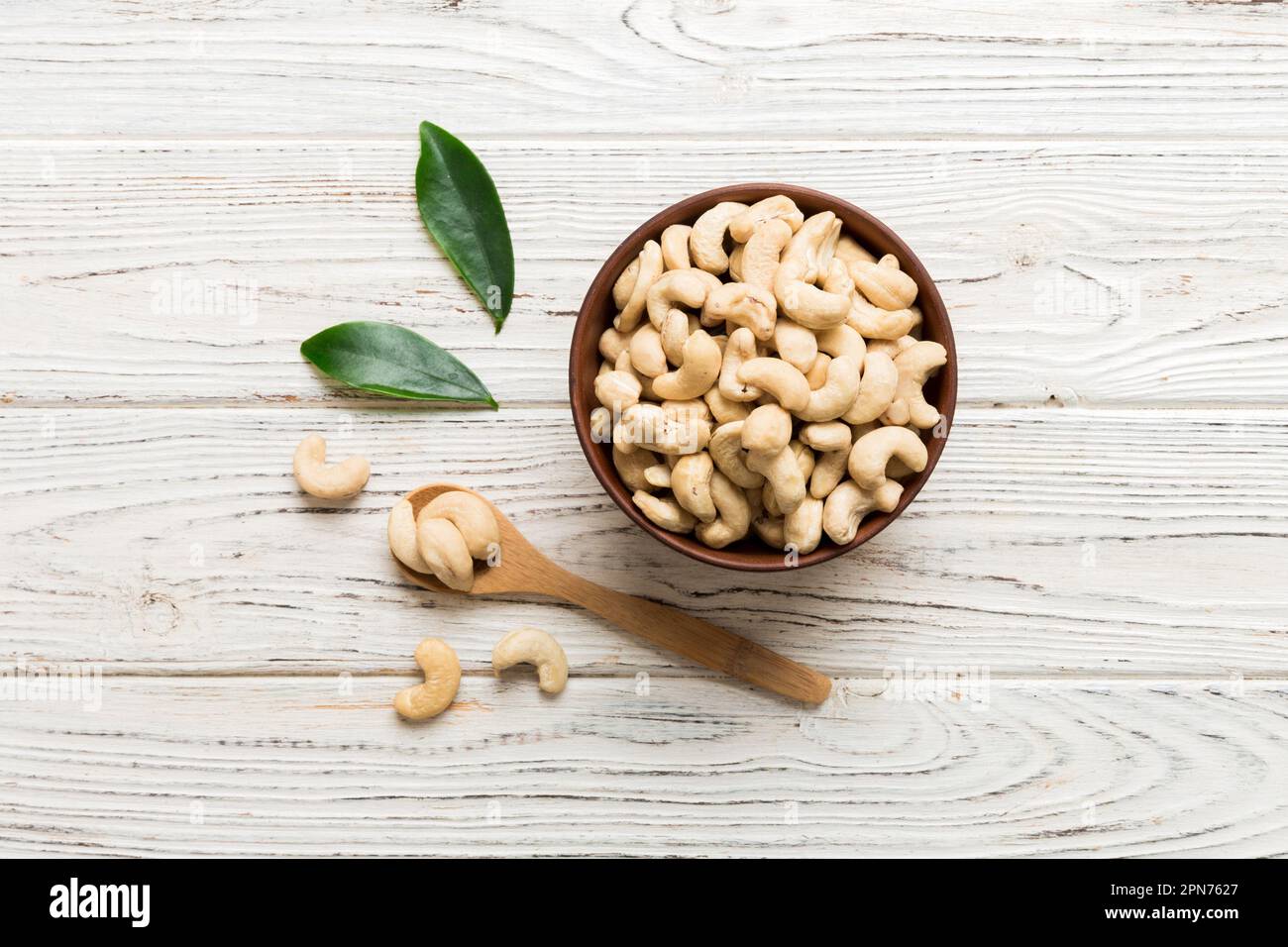 cashew nuts in wooden bowl on table background. top view. Space for ...