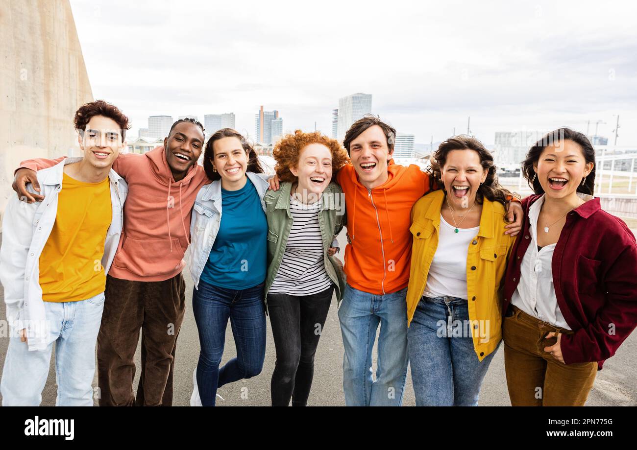 Happy group of teen friends hugging each other smiling at camera ...