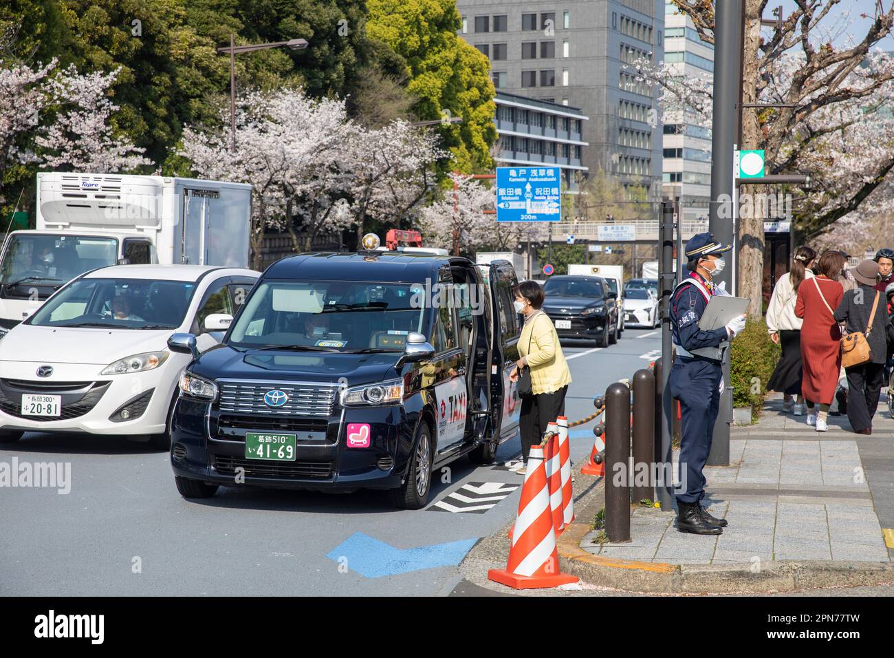 April 2023, Toyota JPN hybrid black taxi stops in Tokyo to pick up a ...