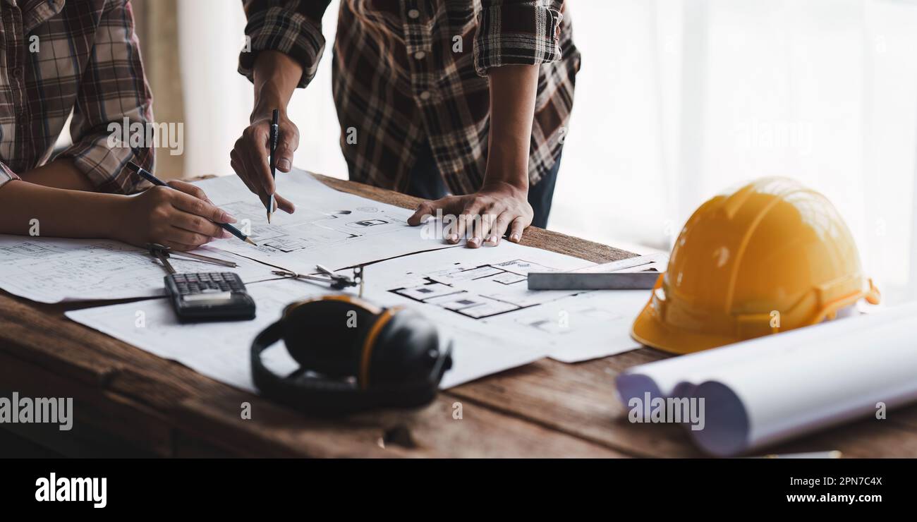 Architect and Engineer working with blueprints for architectural plan ...