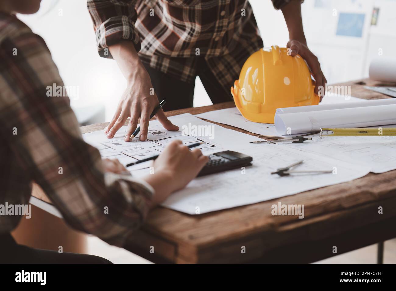 Architect and Engineer working with blueprints for architectural plan ...