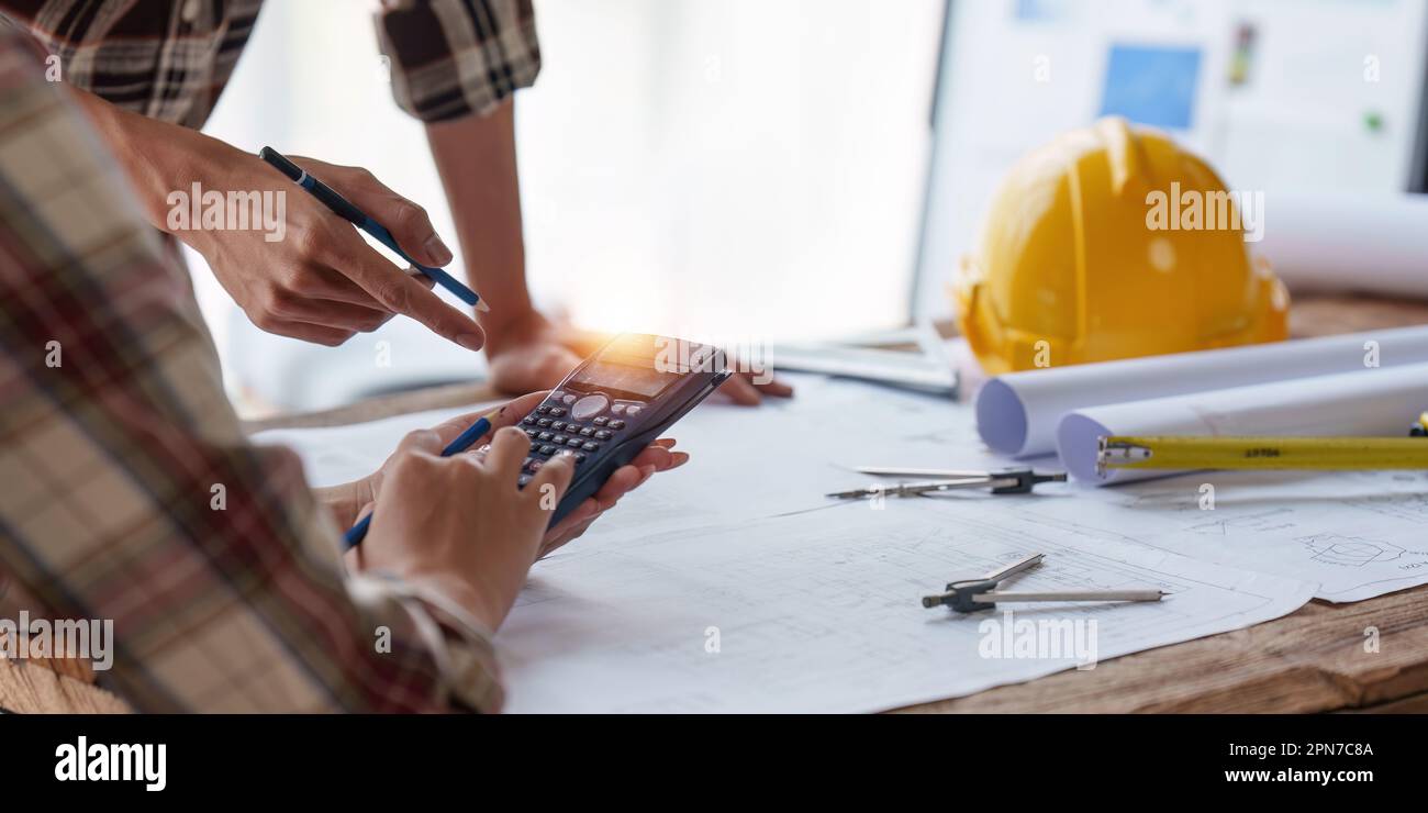 Architect and Engineer working with blueprints for architectural plan ...