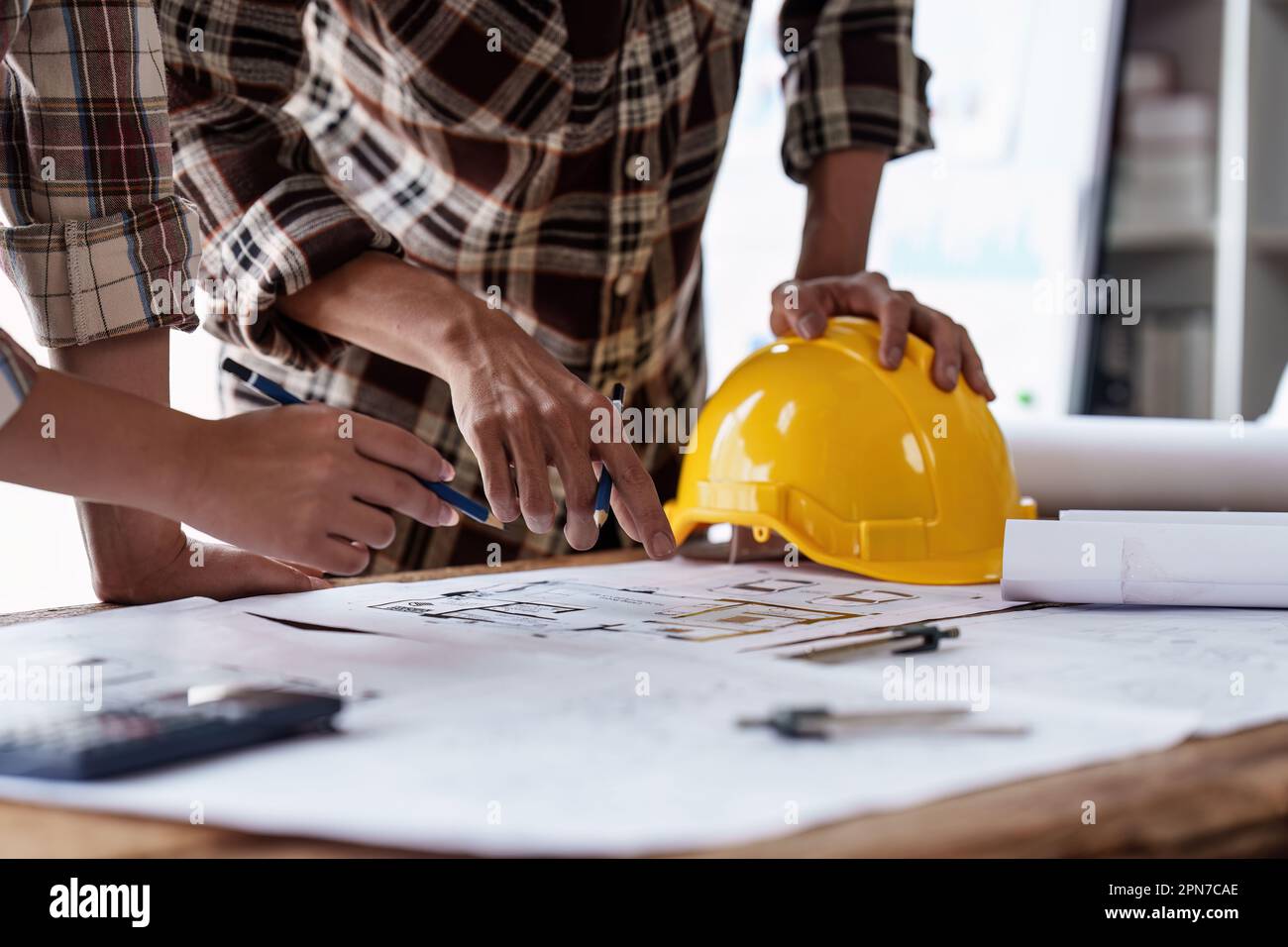 Architect and Engineer working with blueprints for architectural plan ...