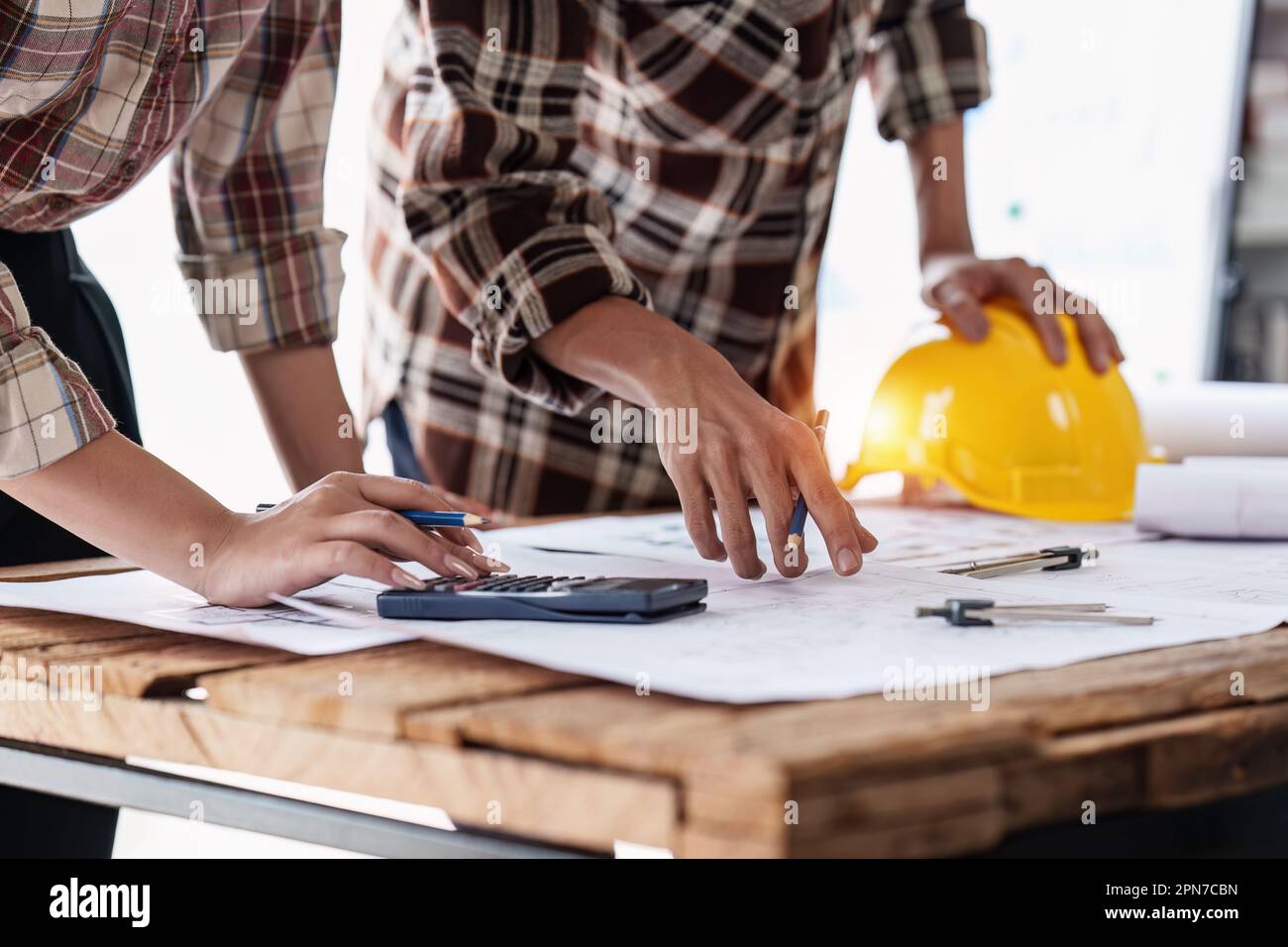 Architect and Engineer working with blueprints for architectural plan ...