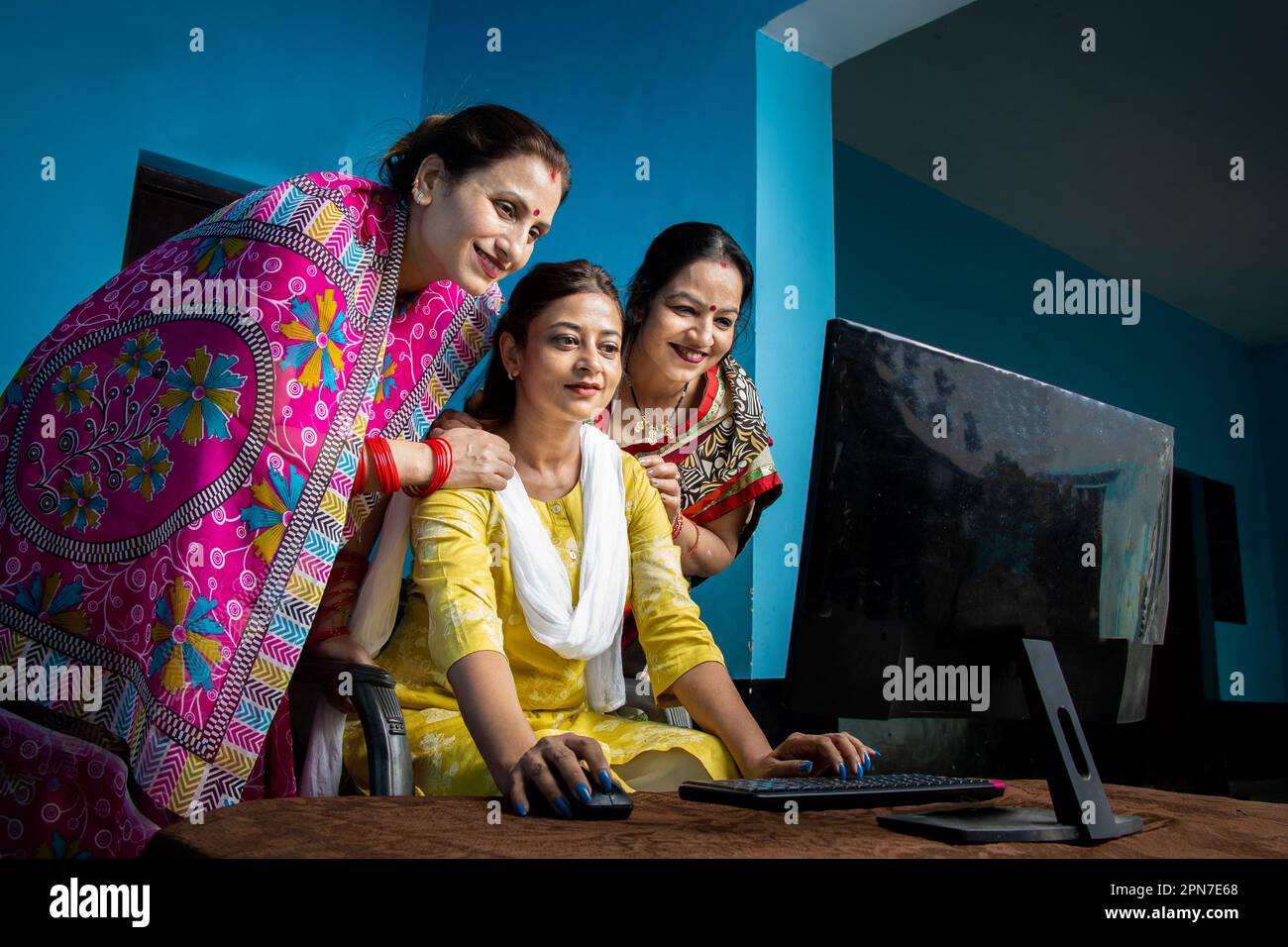 Rural indian women using and learning computer. Young girl teaching and ...