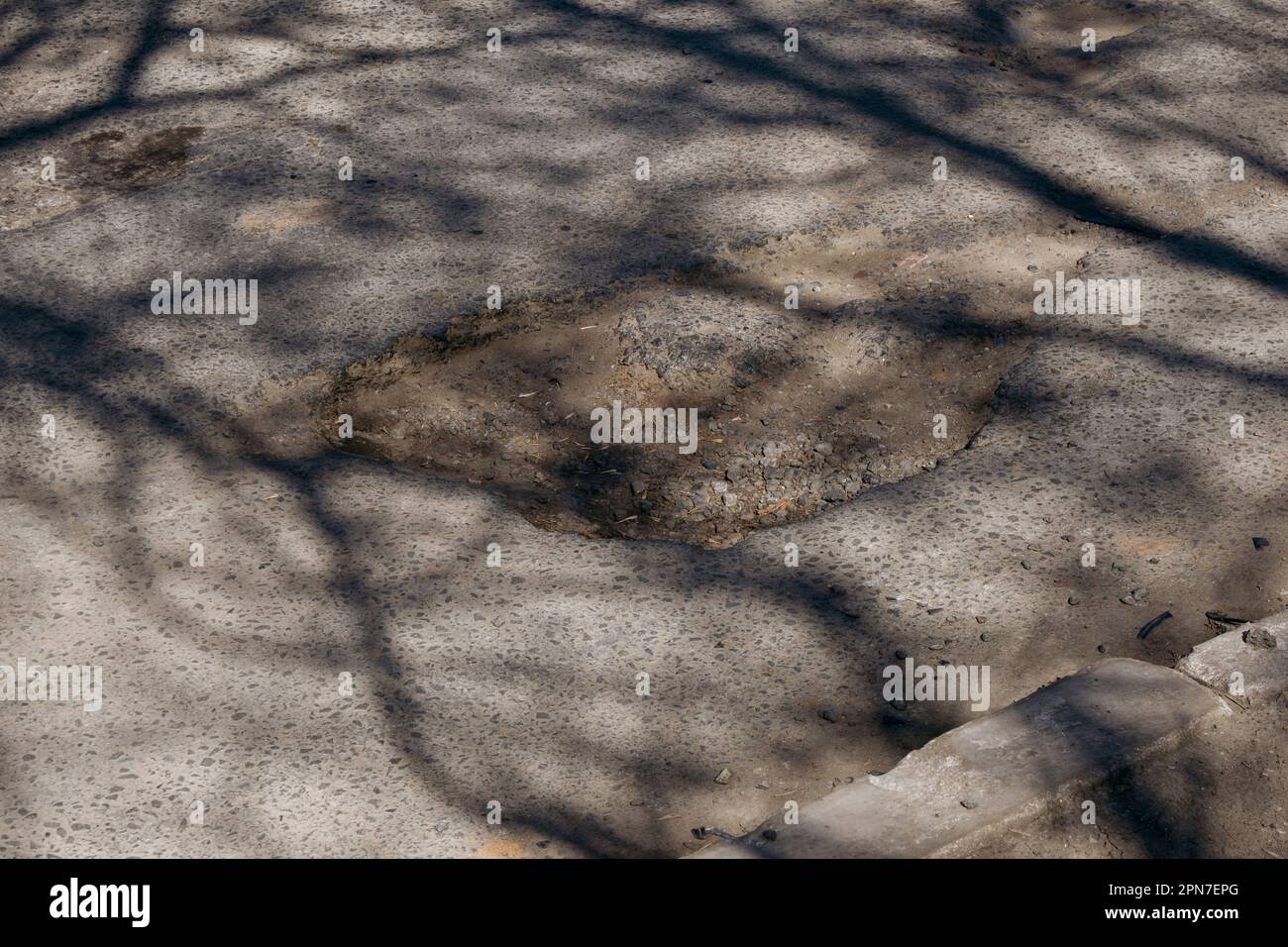 A highway with large pits and shadows from trees Stock Photo - Alamy