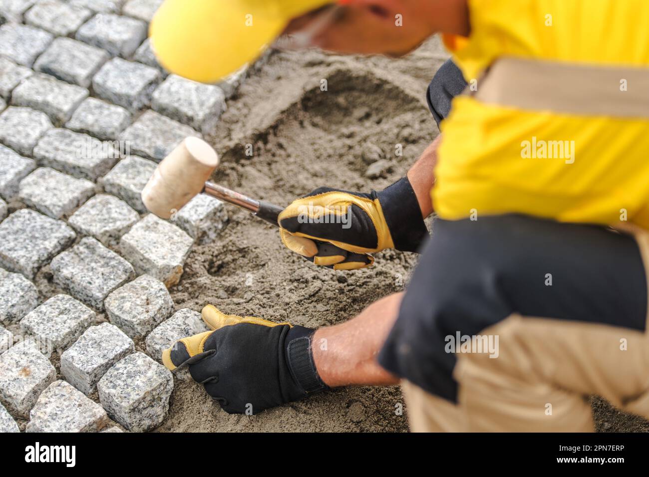 Closeup of Professional Contractor in Yellow Uniform Laying Paving ...