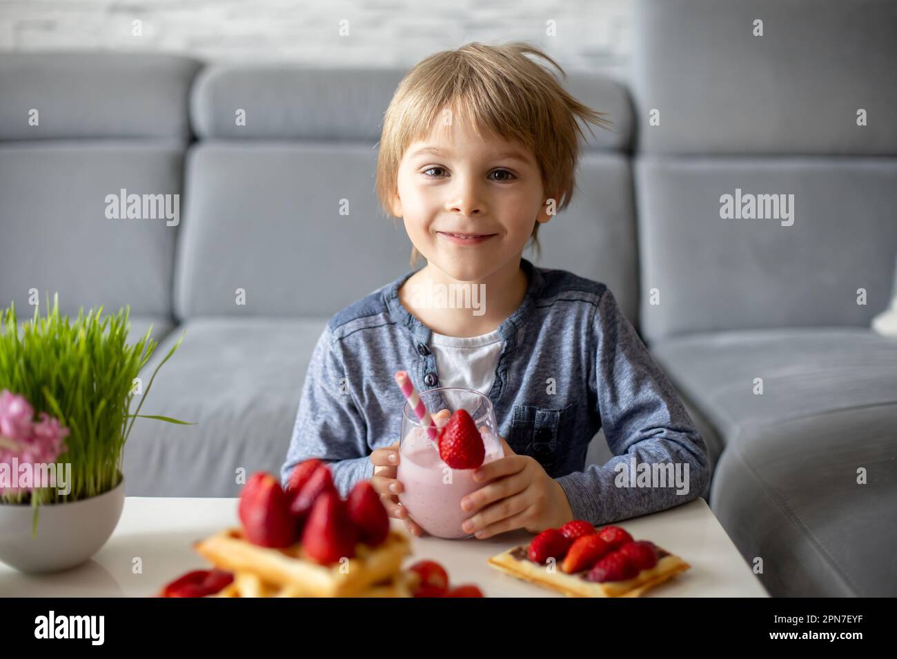 Sweet preschool child, boy, eating belgian waffle with strawberries and ...