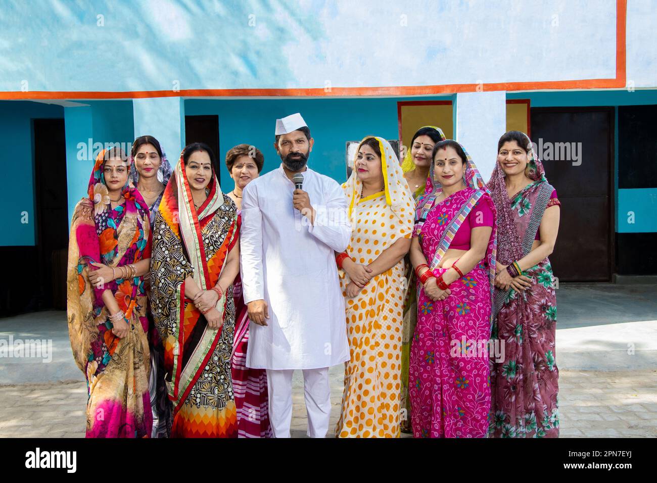 Indian man politician holding mic giving speech with group of ...