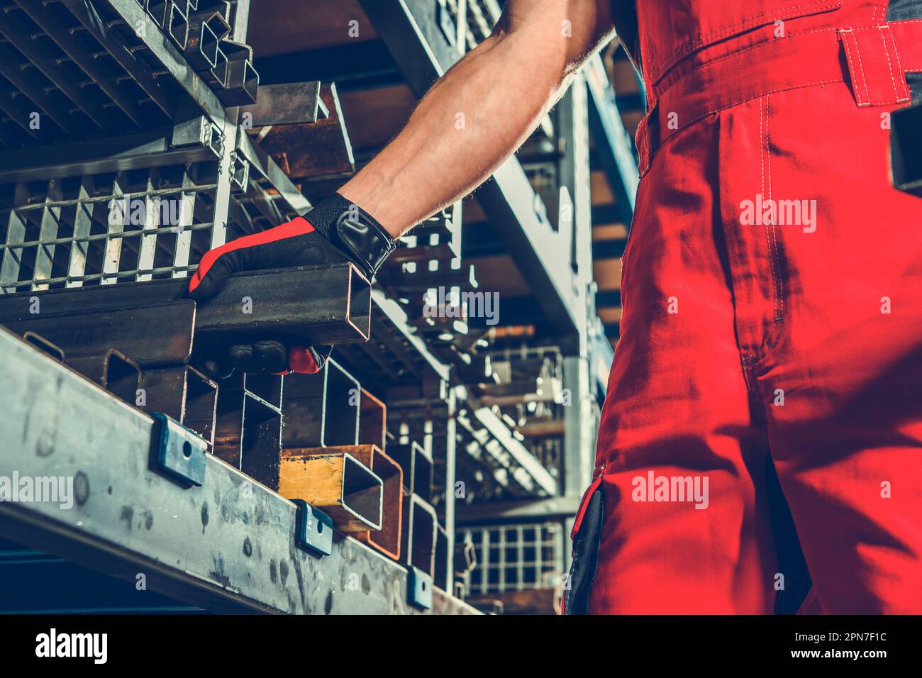 Industrial Production Worker Pulling Out a Metal Square Tube from a ...