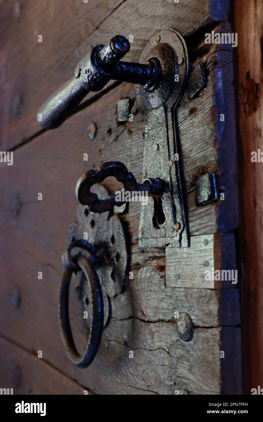 An aged barn door featuring a set of rusted keys resting on the latch ...