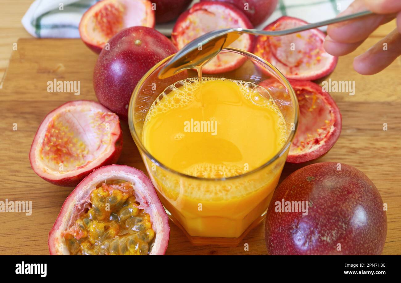 Adding Honey to Sweeten Freshly Squeezed Passion Fruit Juice Stock ...