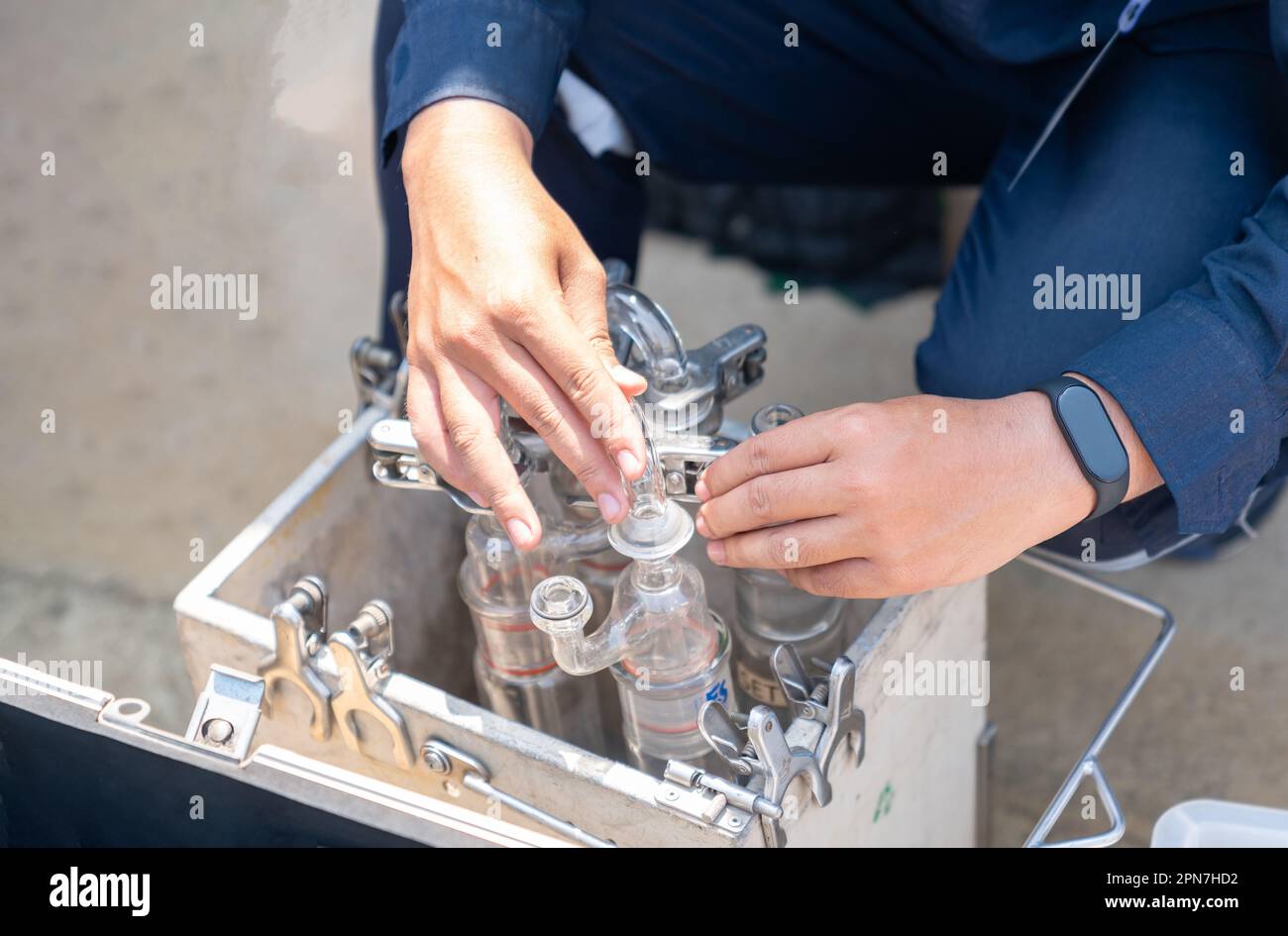 Environment officer with test tube sampling, stack of boiler in factory ...